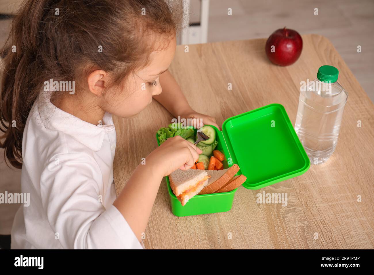 Little girl eating lunch in classroom, closeup Stock Photo - Alamy