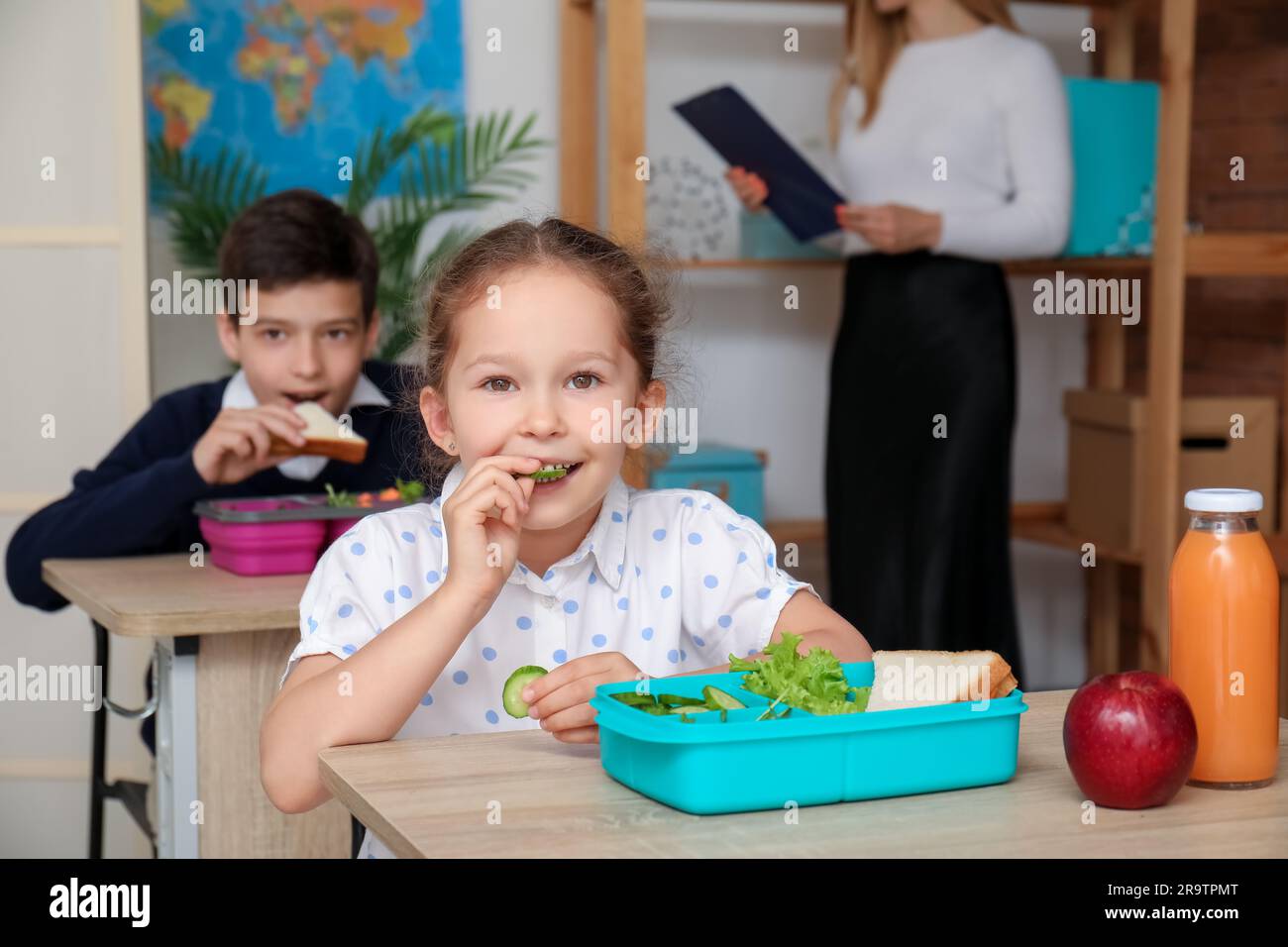 Little girl eating lunch in classroom Stock Photo - Alamy