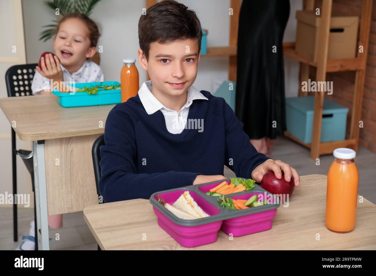 Little boy eating lunch in classroom Stock Photo - Alamy