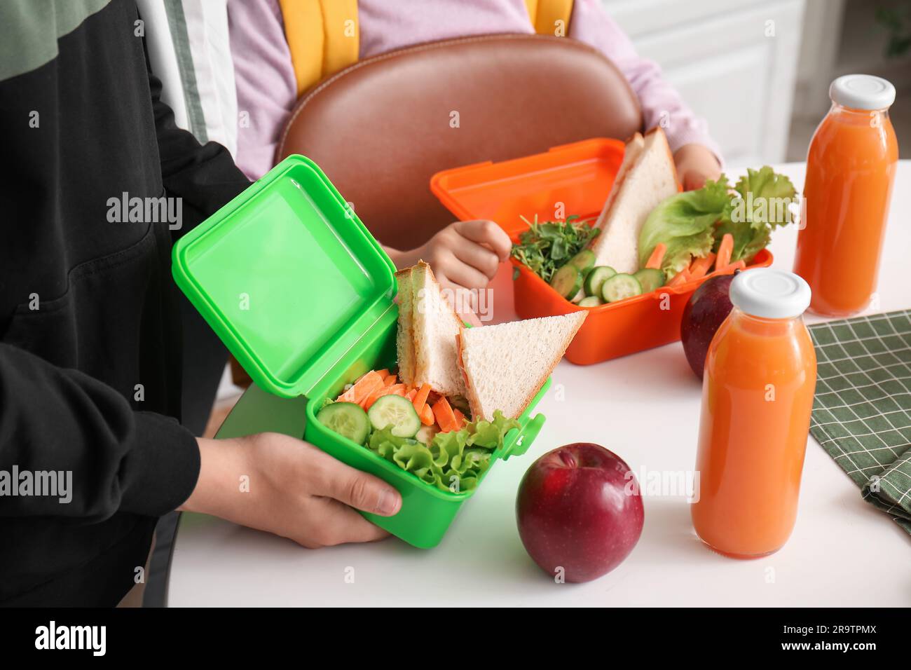 Little children with school lunch and their mother in kitchen, closeup ...