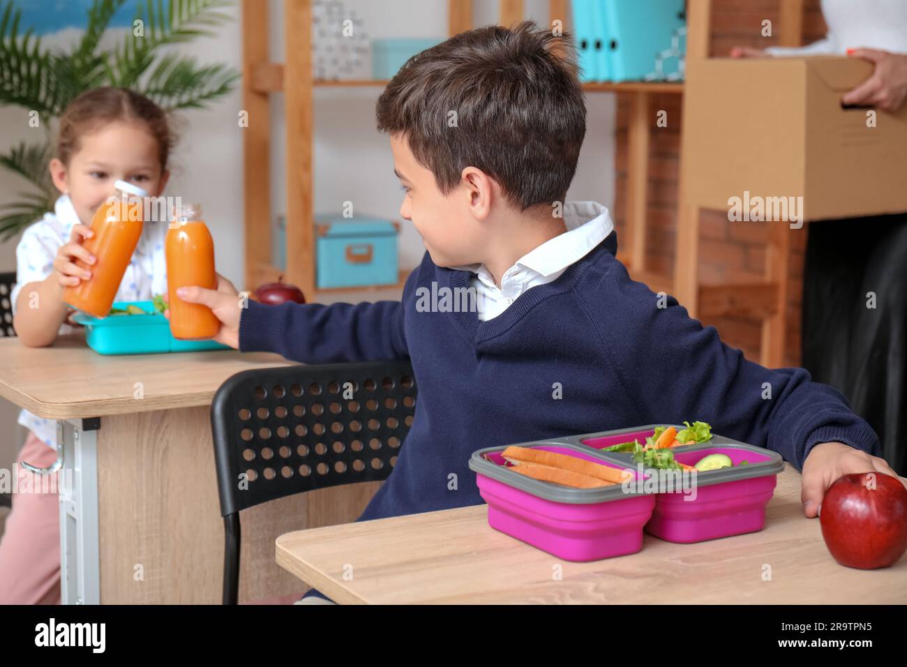 Little boy having lunch in classroom Stock Photo - Alamy