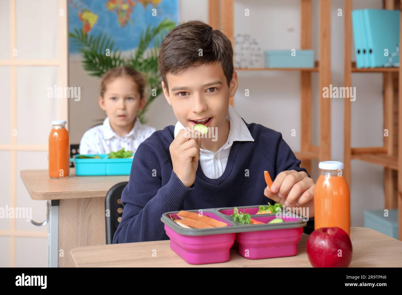 Little boy eating lunch in classroom Stock Photo - Alamy