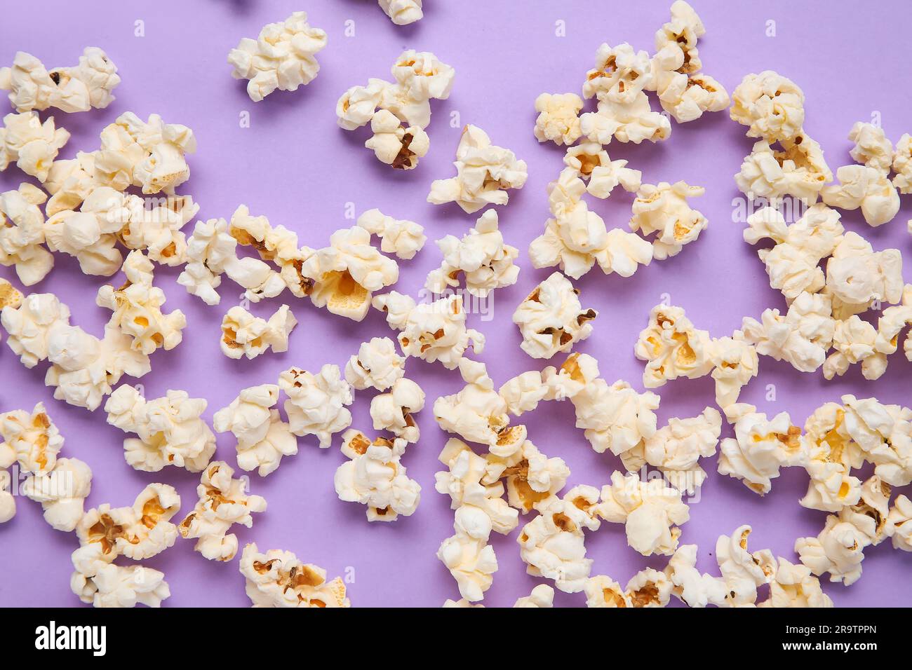 Tasty popcorn on purple background Stock Photo - Alamy