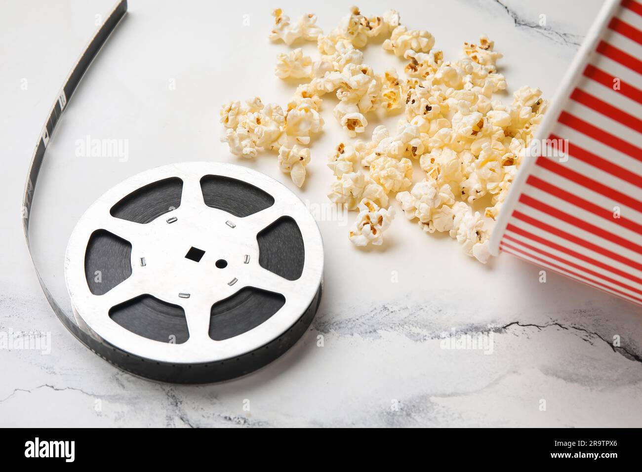 Bucket with tasty popcorn and film reel on white background Stock Photo ...