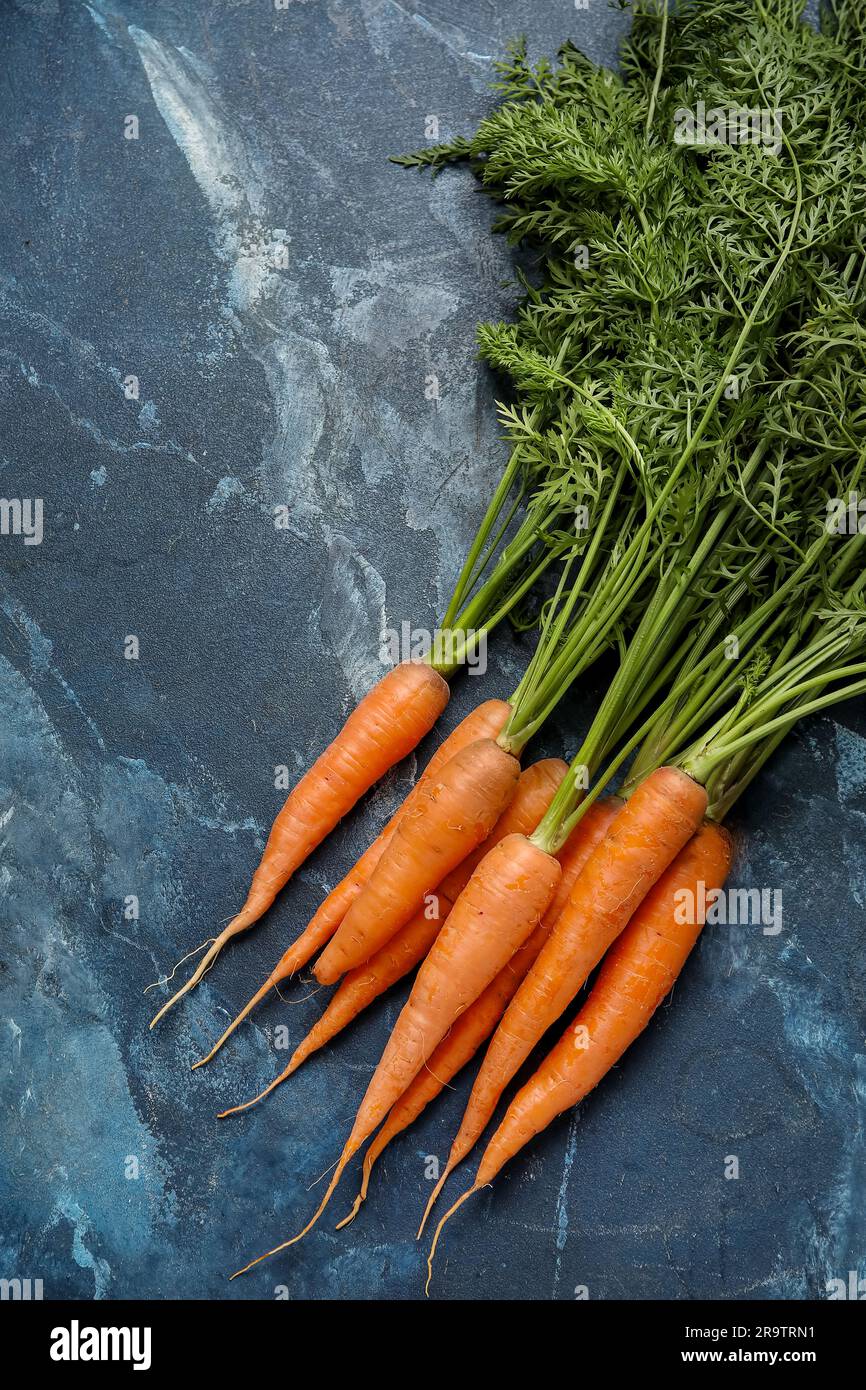 Fresh carrots with leaves on blue background Stock Photo - Alamy