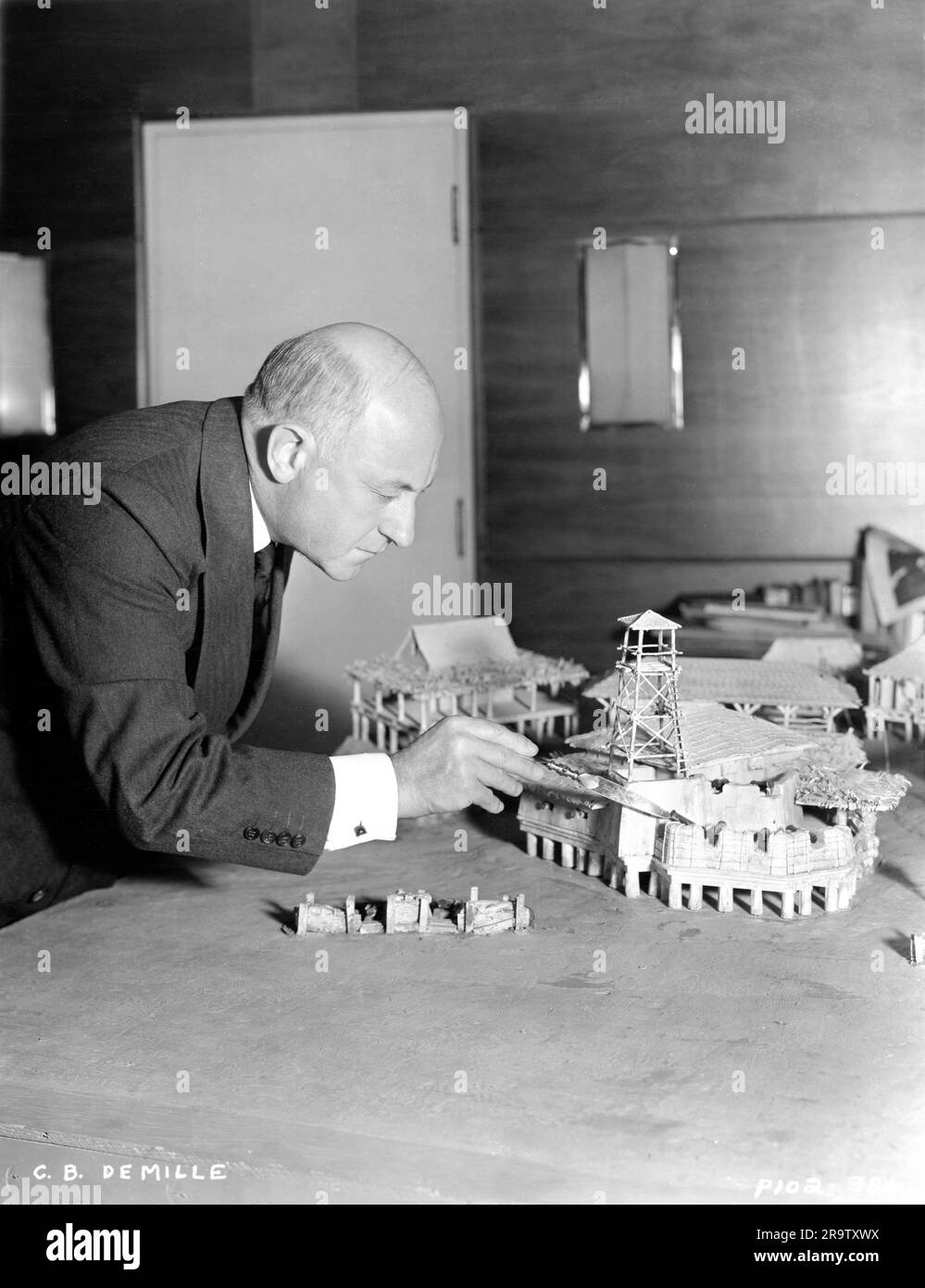 CECIL B. DeMILLE inspects a Set Model of Jean Lafitte's Barataria ...