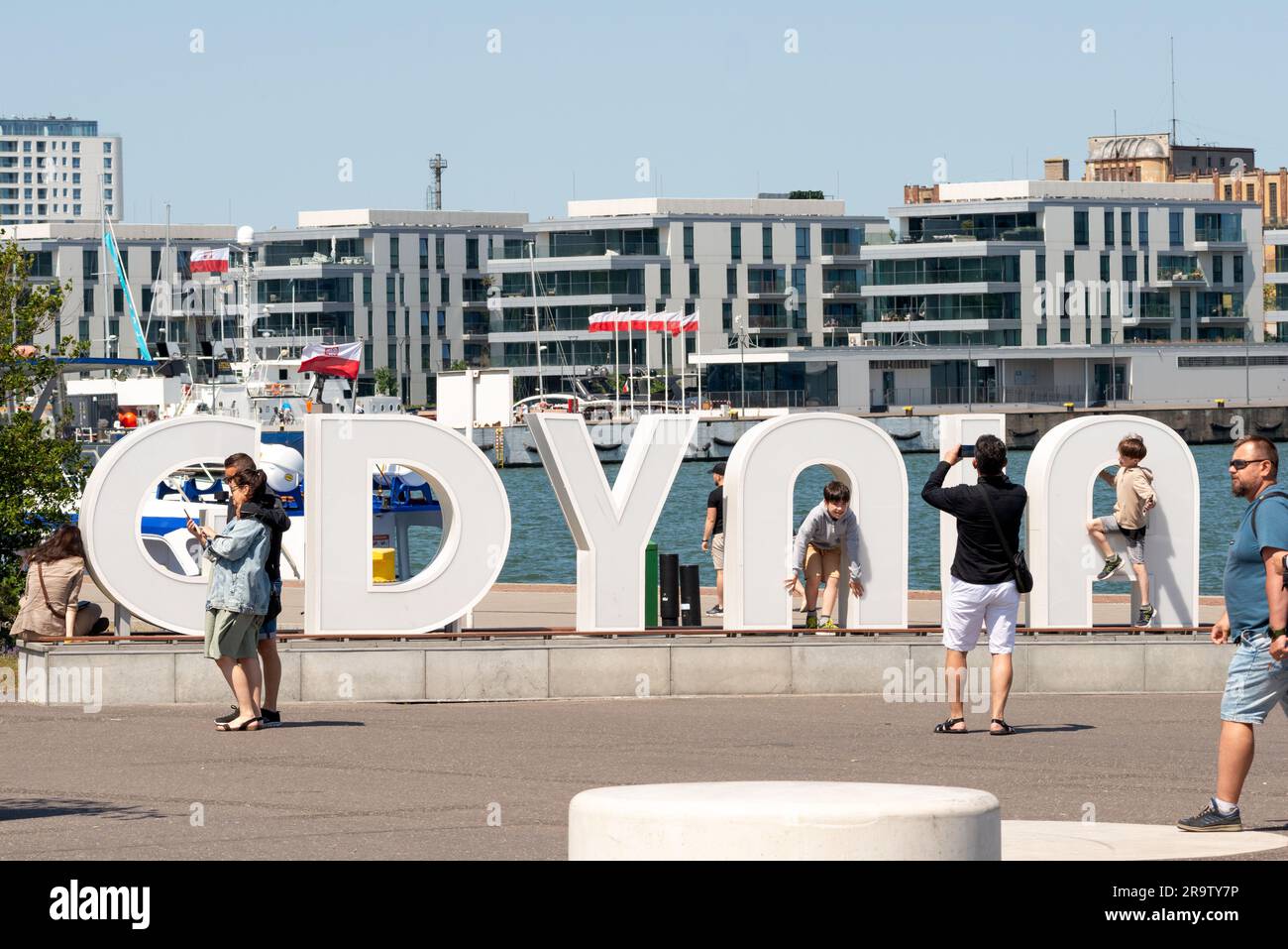 Gdynia sign symbol and tourists taking selfies at the city harbour in ...