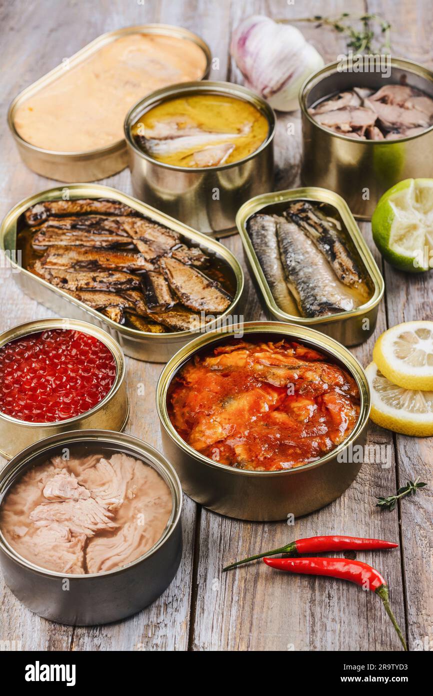 Variety of opened cans with different types of tinned fish and seafood ...