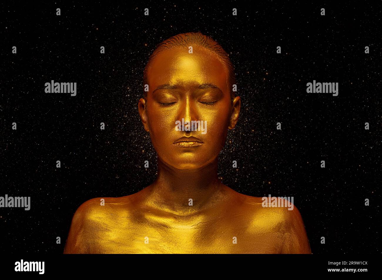 Model girl with festive golden glamorous shiny professional make-up. Beautiful golden metallic ...