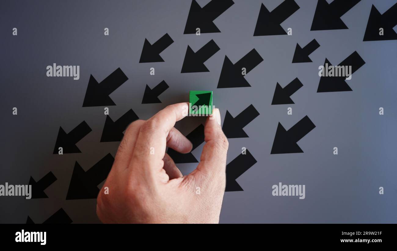 Hand pick wooden block with opposite pointing arrow than others. Unique ...