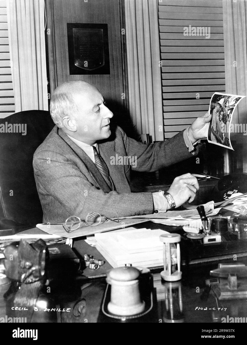 CECIL B. DeMILLE in his office at Paramount Studios holding a publicity ...