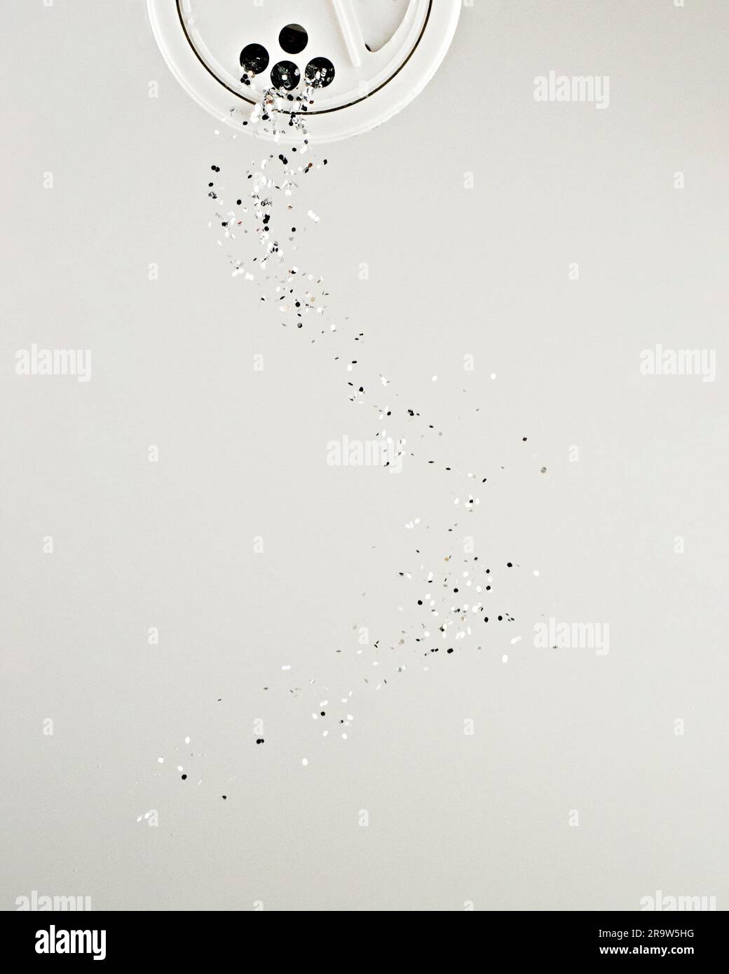 A silver glitter being shaken against a white background Stock Photo ...