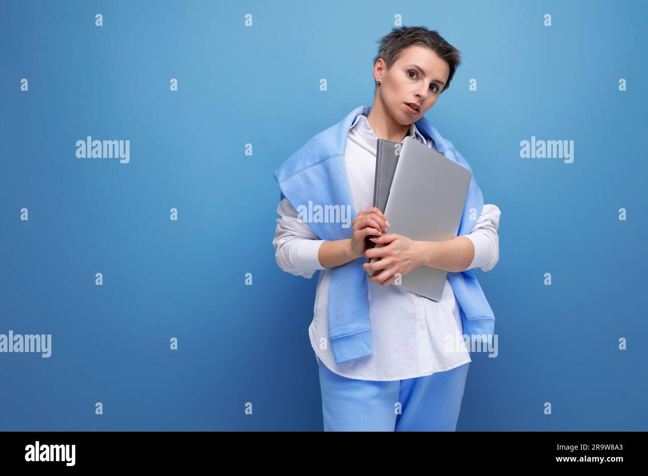 confident stylish freelancer woman with laptop on studio background ...
