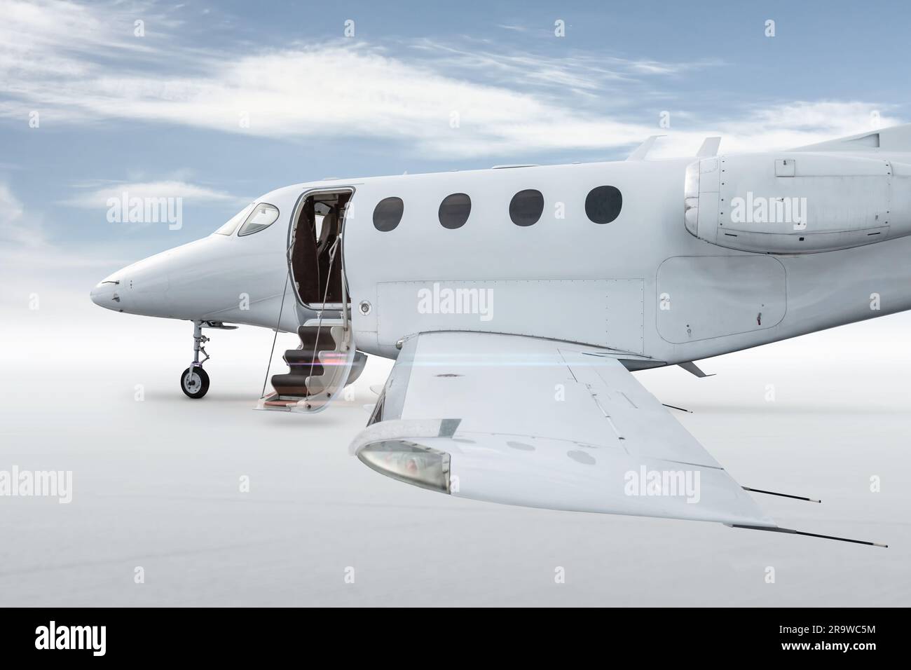 Close-up of the modern white private jet with an opened gangway door ...