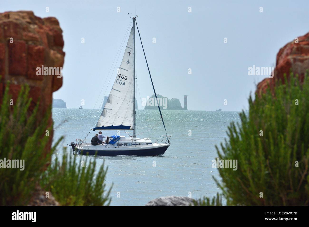 Yacht sailing past the Needles of the Isle of Wight Stock Photo - Alamy