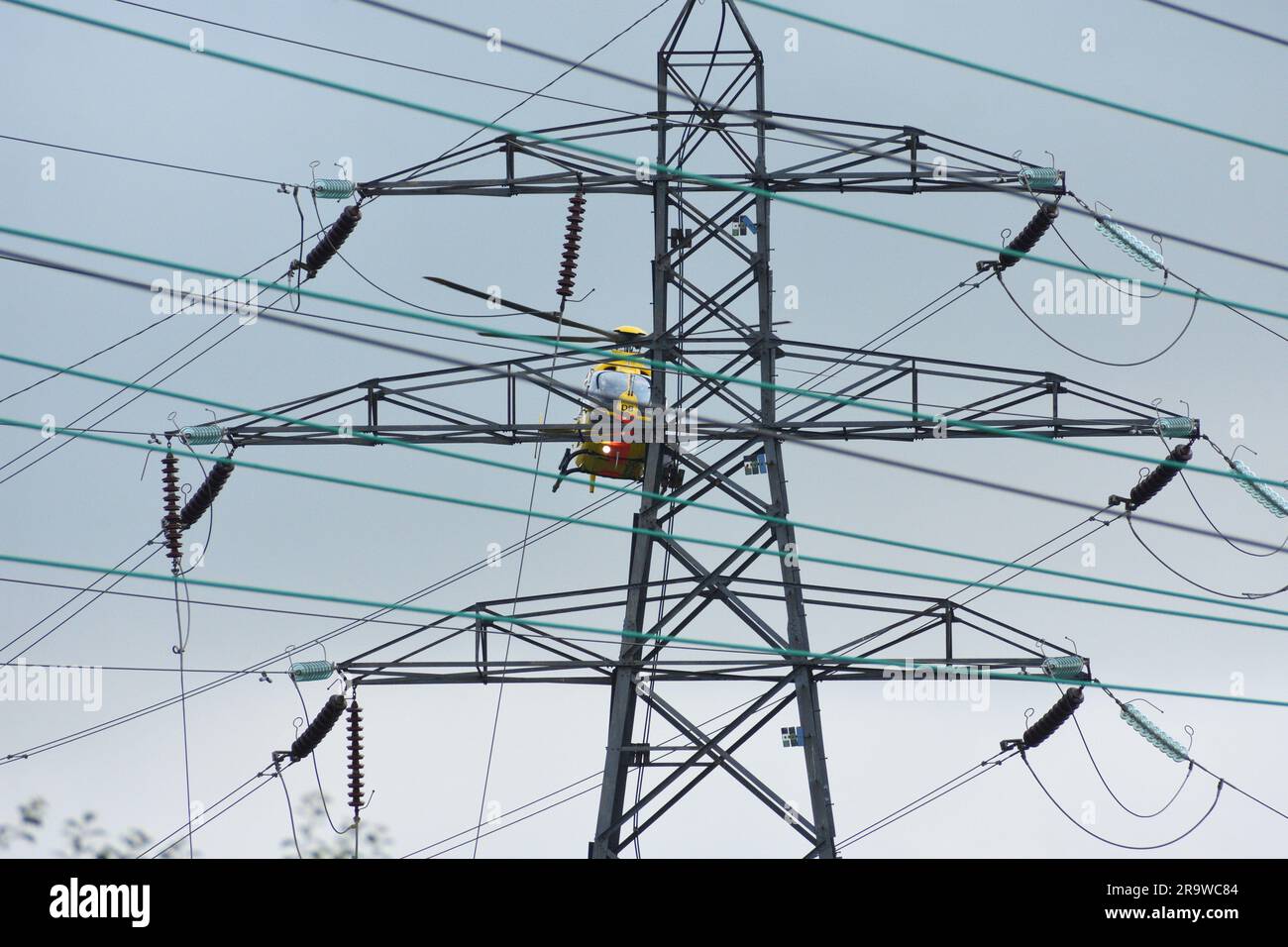 Yellow Airbus Helicopter close to high power pylon lines Stock Photo ...