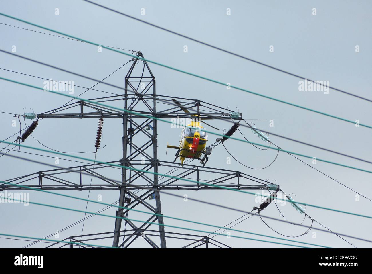 Yellow Airbus Helicopter very close to pylon power lines Stock Photo ...