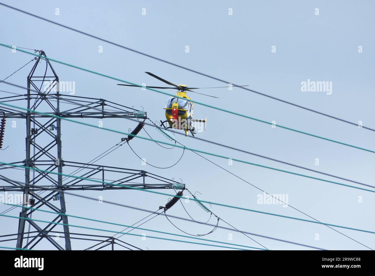 Yellow Airbus Helicopter very close to high power lines Stock Photo - Alamy