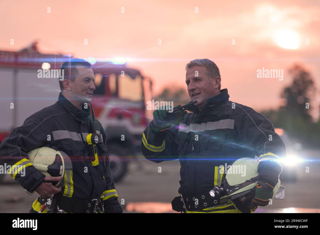 Fireman using walkie talkie at car traffic rescue action fire truck and ...