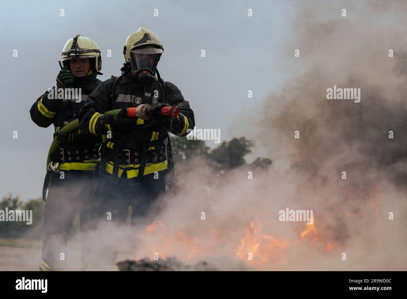 Firefighters fight the fire flame to control fire not to spreading out ...