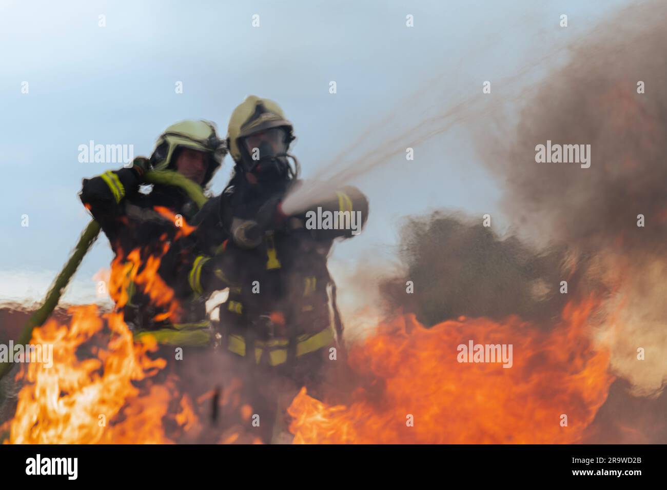 Firefighters fight the fire flame to control fire not to spreading out ...