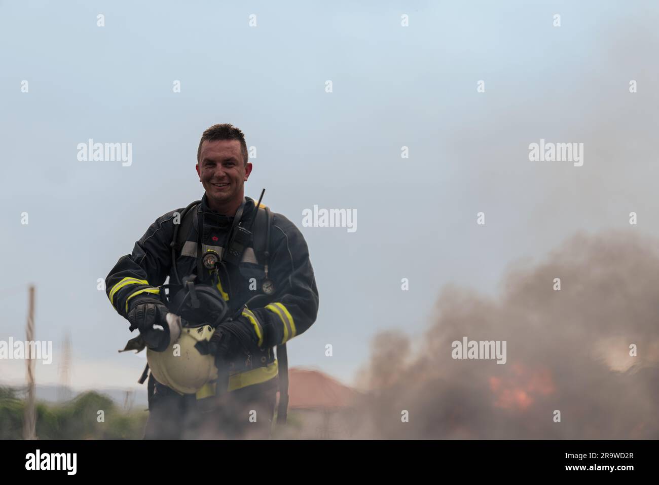 Portrait of a heroic fireman in a protective suit. Firefighter in fire ...