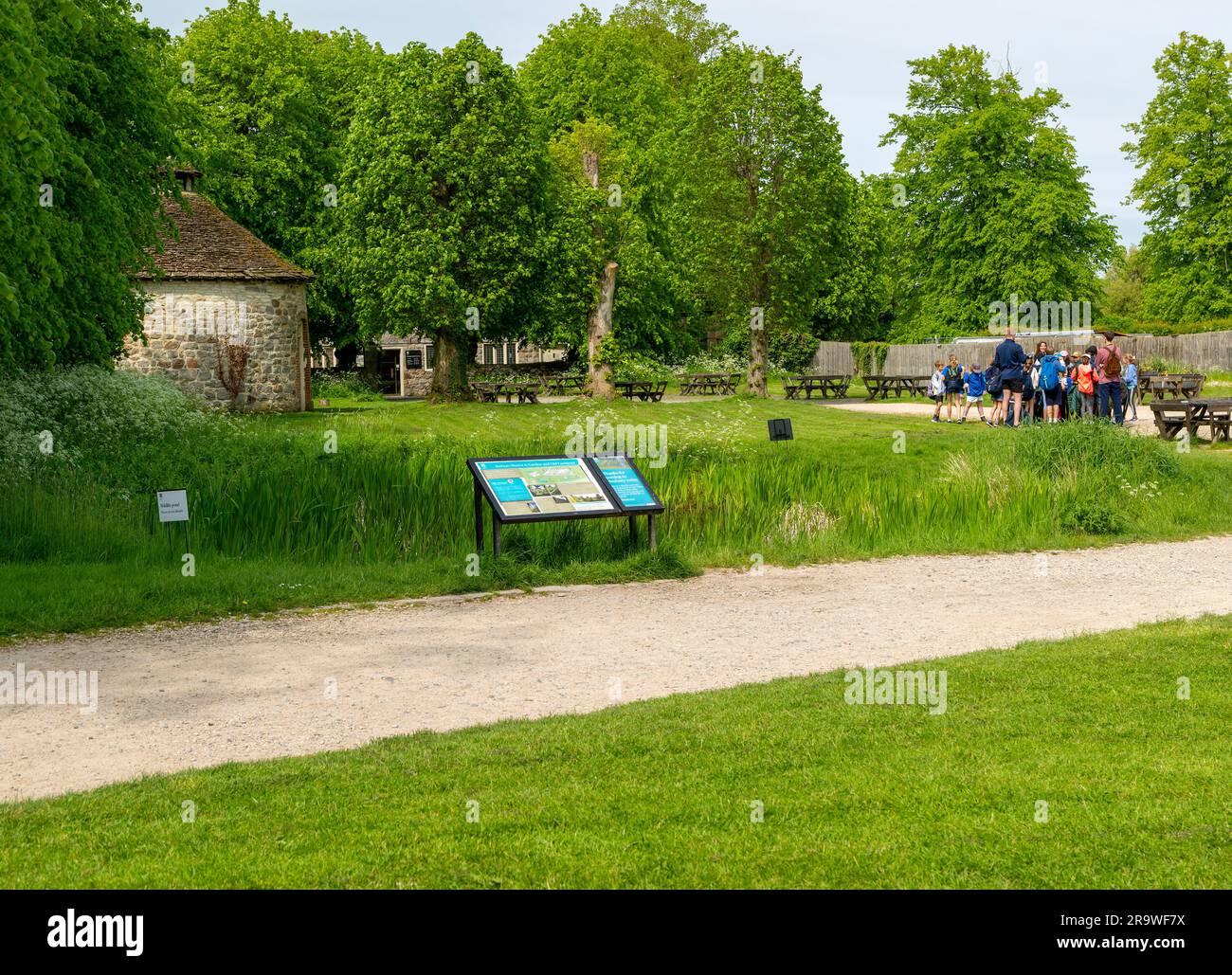 Dovecote building, pond children in school group, Avebury, Wiltshire ...