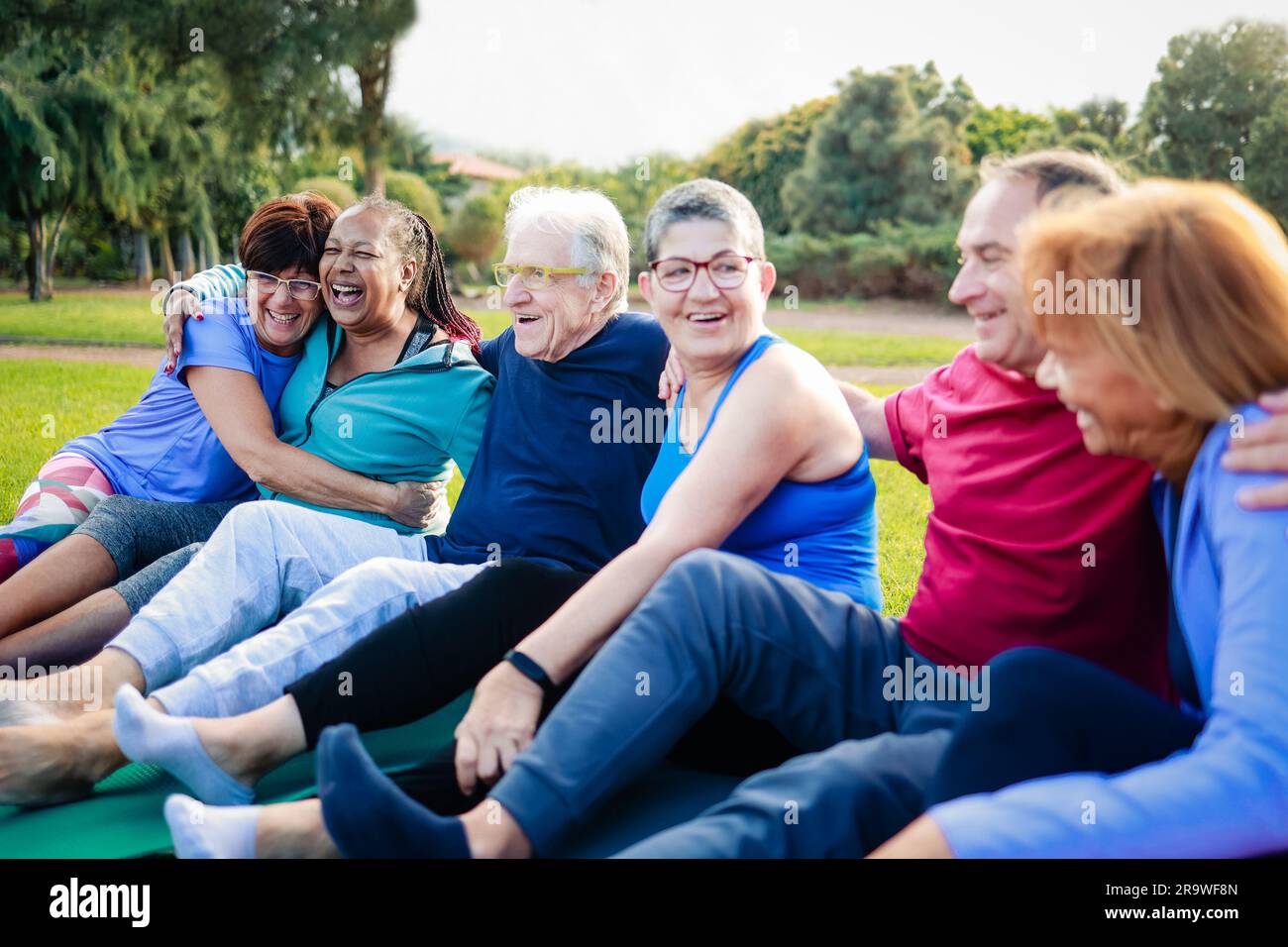 Happy senior people after yoga sport class having fun sitting outdoors ...