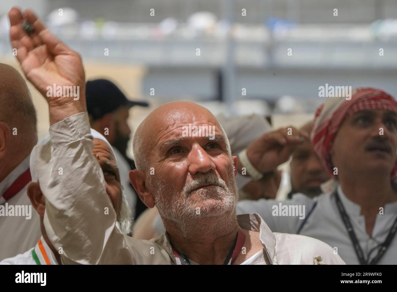 An Iranian pilgrim casts a stone at a pillar in the symbolic stoning of ...