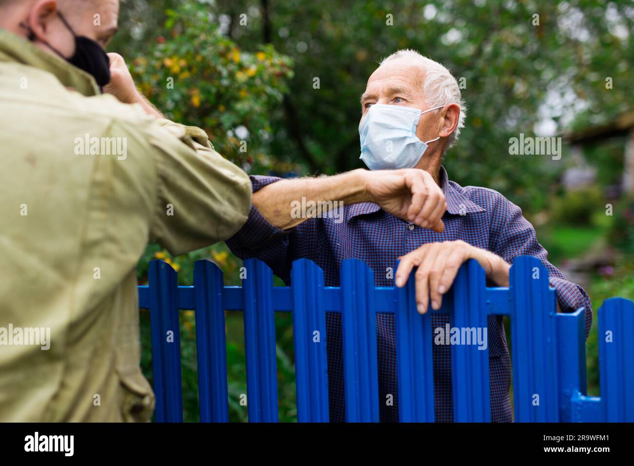 Good neighbors greet each other with touch of their elbows. Safe ...