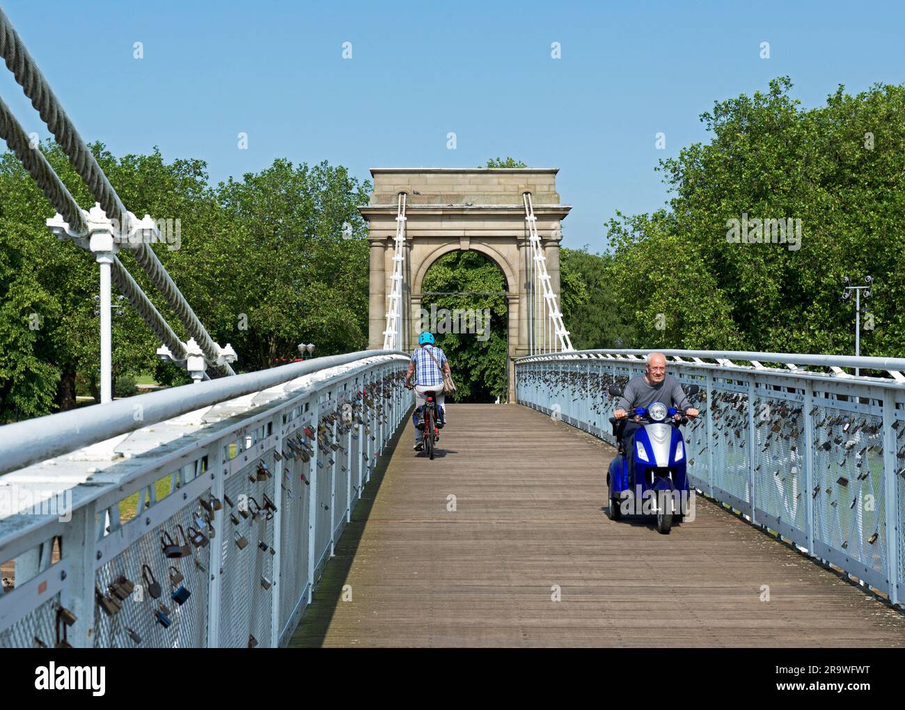 Cyclist and man on mobility scooter crossing Wilford footbridge ...