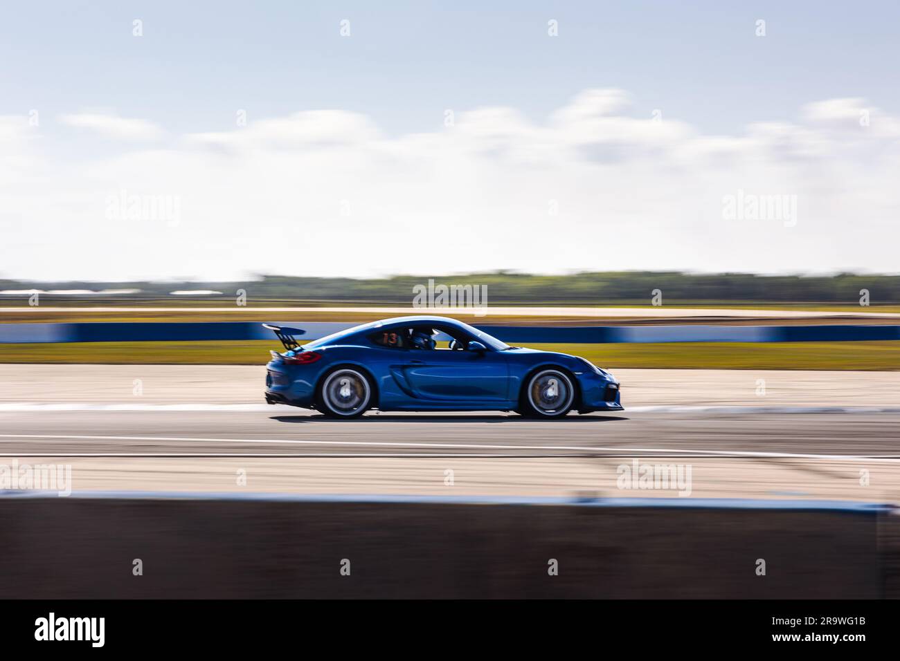 Blue Porsche Cayman GT4 racing at Sebring International Raceway through ...
