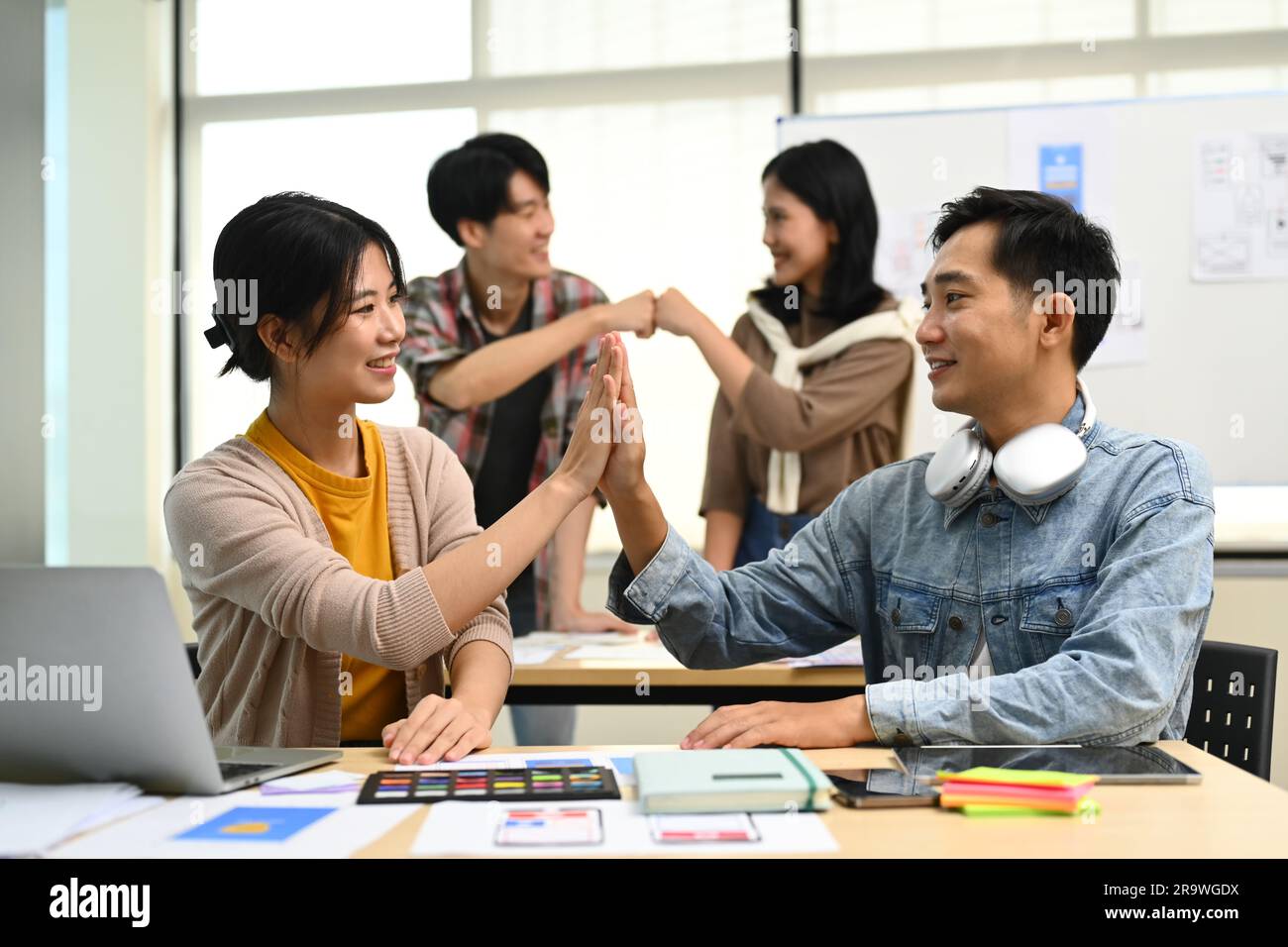 Happy asian female employee giving high five with colleague ...