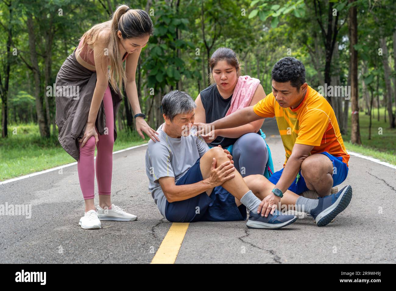 A middle age man with knee pain grabbing his knee with both hands while ...