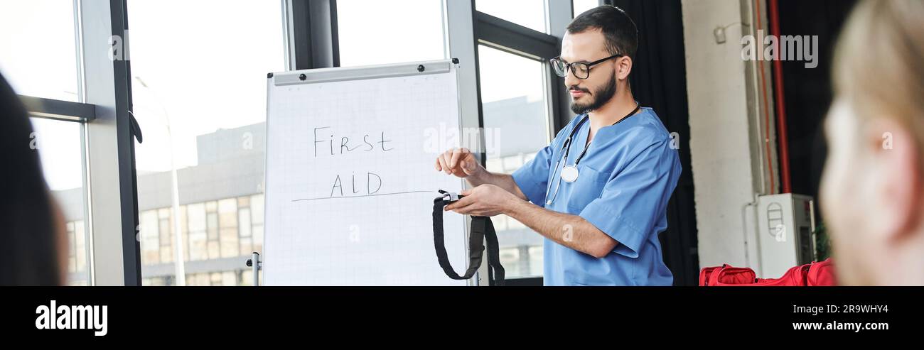 young healthcare worker in eyeglasses and blue uniform showing ...