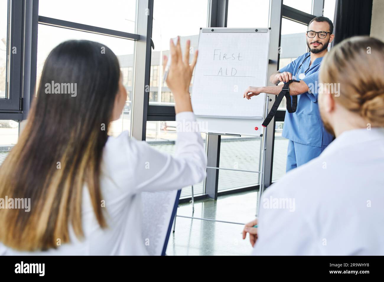 medical instructor with compressive tourniquet standing at flip chart ...