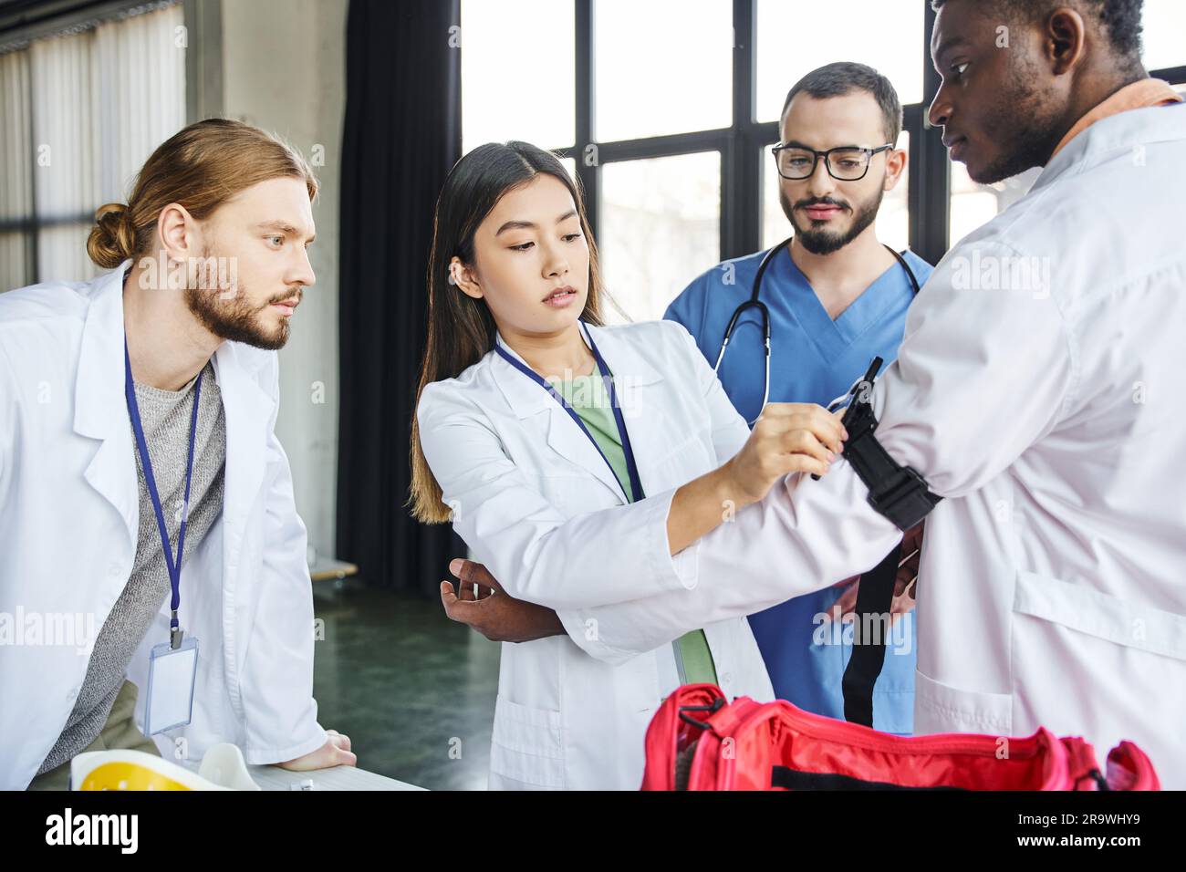 paramedic in eyeglasses looking at young asian woman applying ...