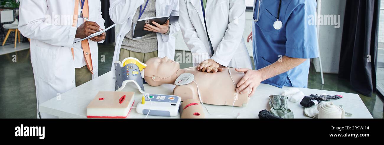partial view of woman in white coat doing chest compressions on CPR ...