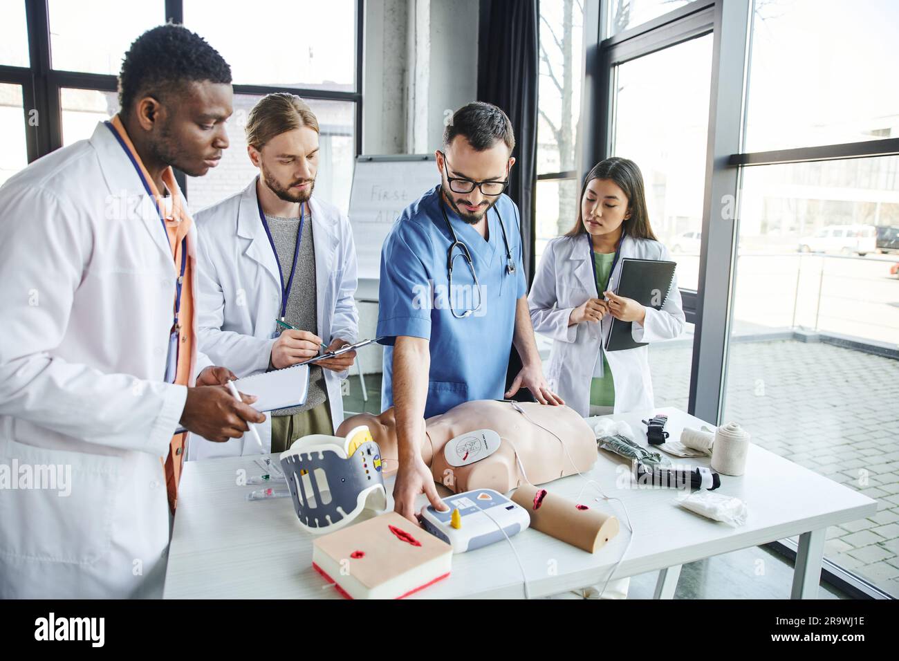 healthcare worker showing defibrillator, CPR manikin and medical ...