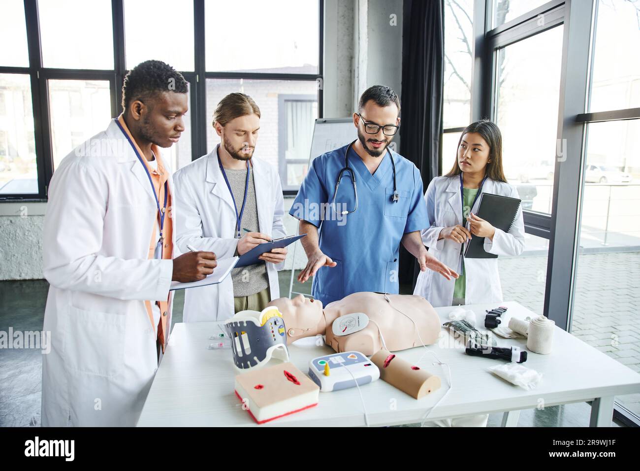 professional paramedic talking and showing CPR manikin, external ...