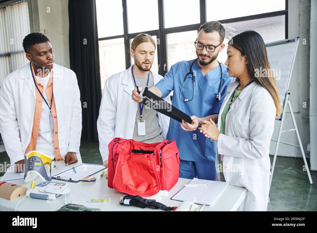 first aid seminar, paramedic in uniform and eyeglasses showing ...