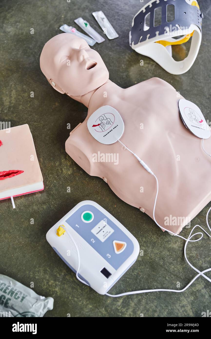 high angle view of CPR manikin, external defibrillator, wound care simulator, neck brace and ...