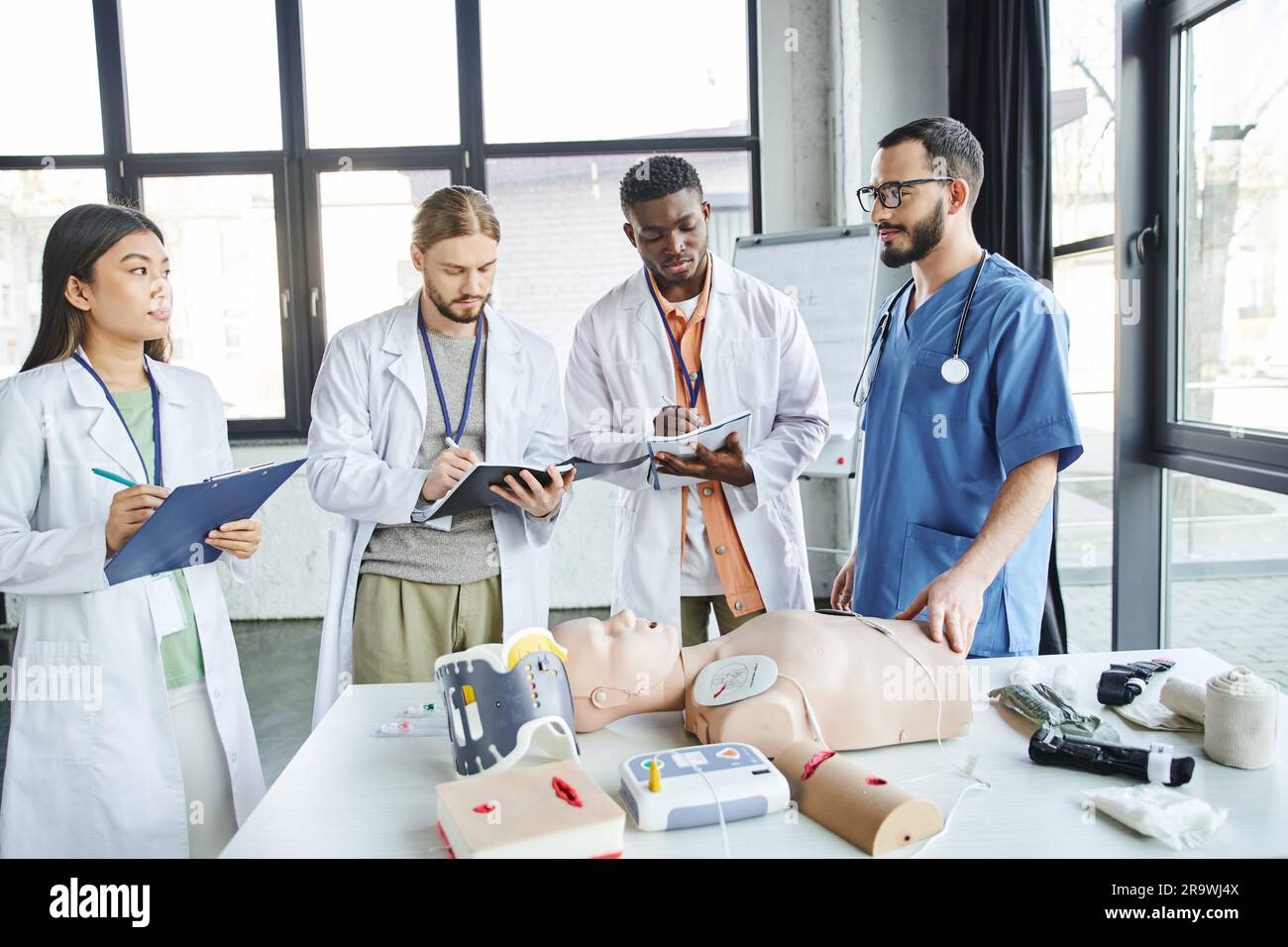 first aid seminar, diverse group of multiethnic students in white coats ...