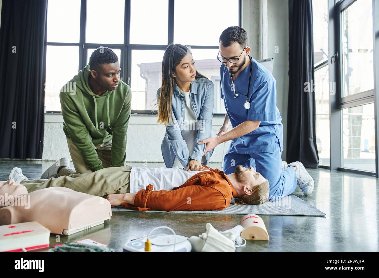 african american man looking at paramedic assisting asian woman doing chest compressions on ...