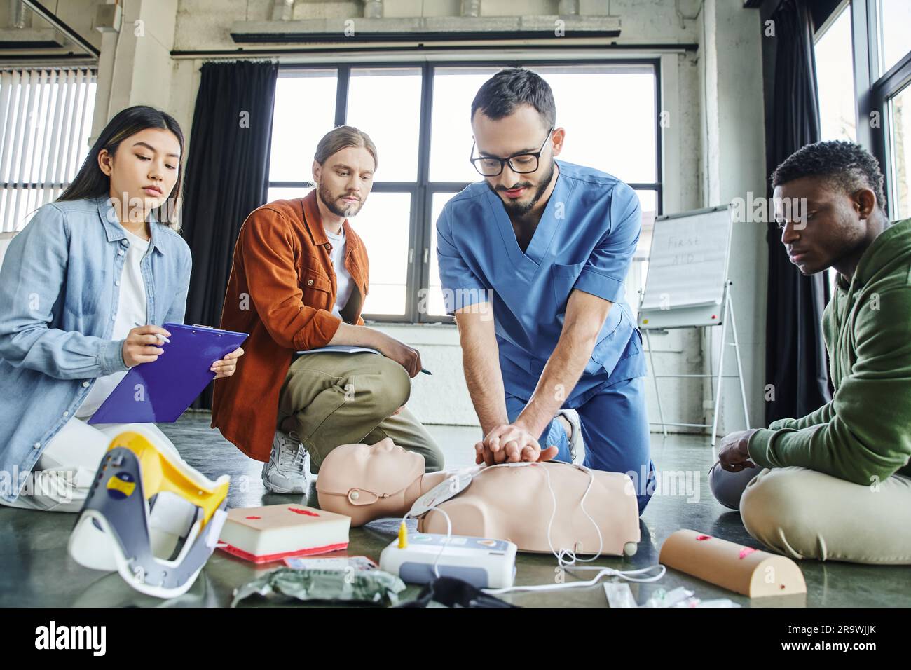 young asian woman with clipboard looking at paramedic doing chest ...