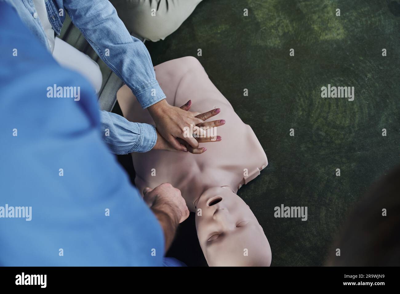 first aid seminar, top view of young woman practicing life-saving skills while doing chest ...