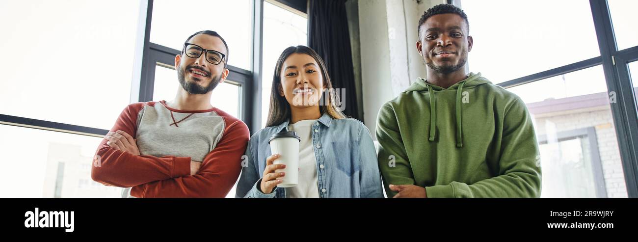 joyful asian woman with coffee to go and multiethnic businessmen with ...
