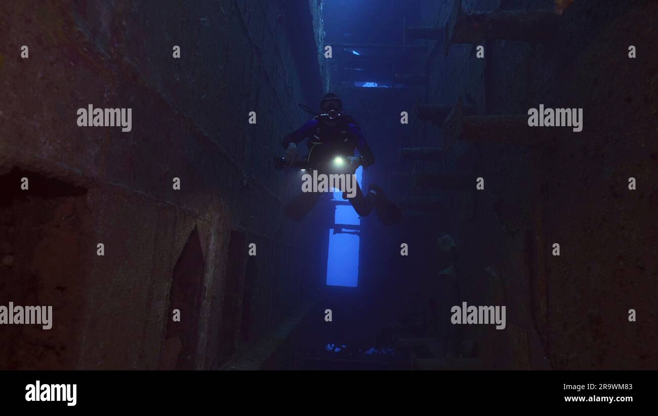 Scuba diver with lantern floats inside of ferry Salem Express shipwreck ...