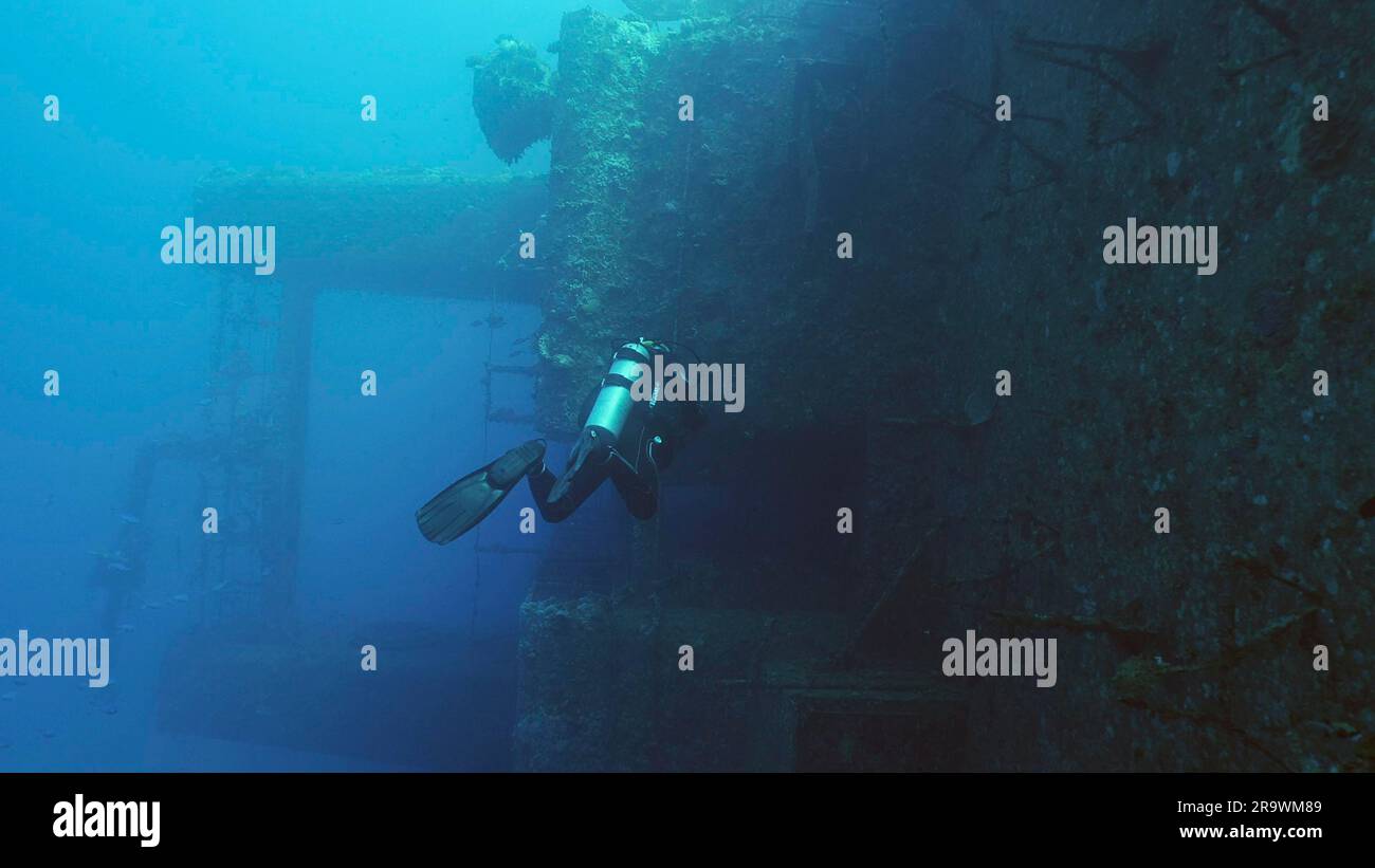 Scuba diver swim along deck of ferry Salem Express shipwreck, Back view ...