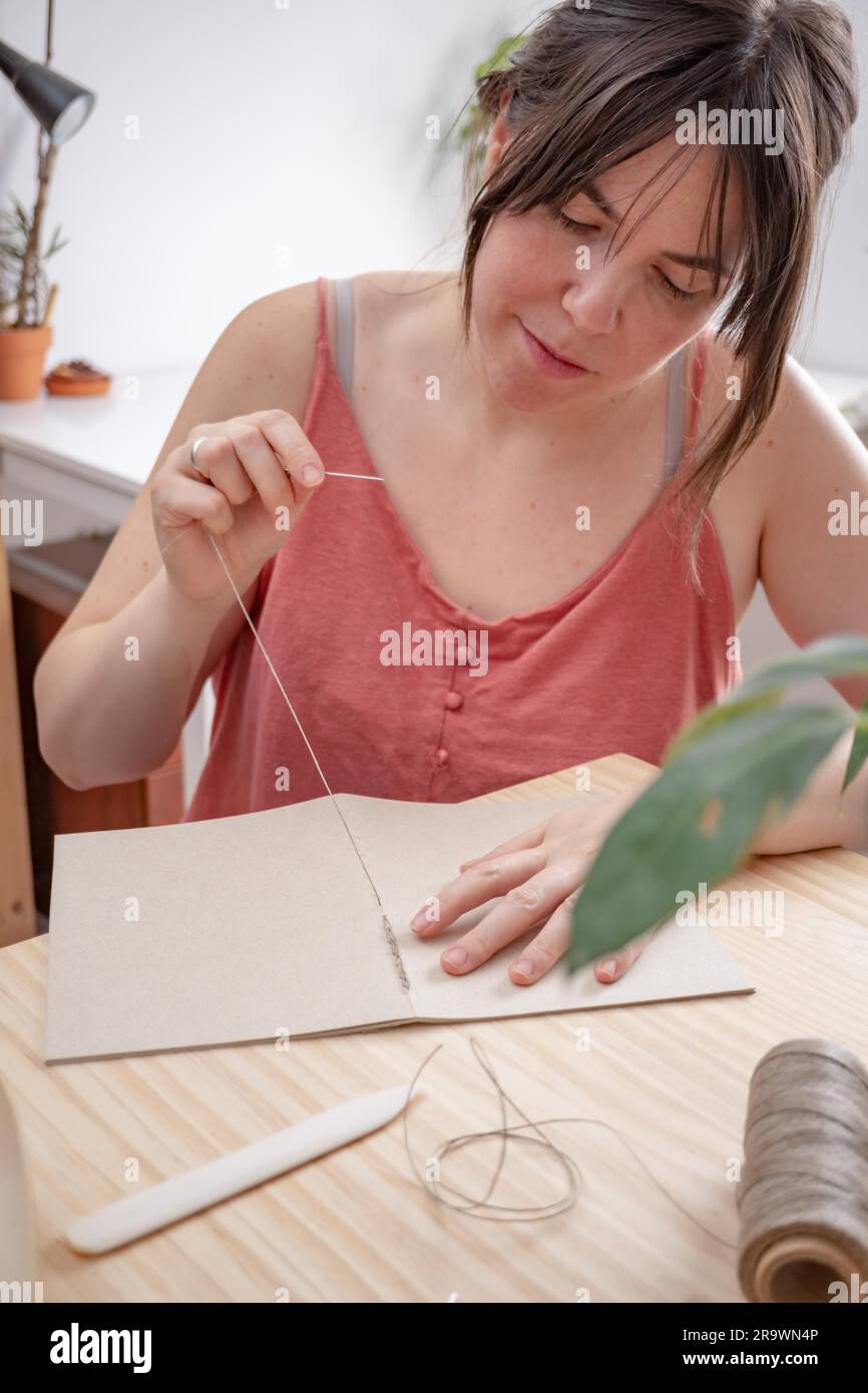 Young artisan girl making notebooks with eco-friendly materials in her ...